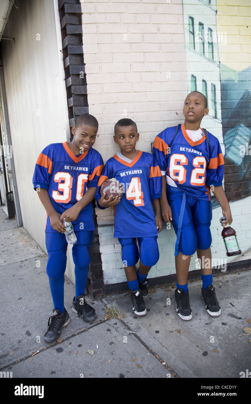 Three young friends & teammates in uniform after their first football ...