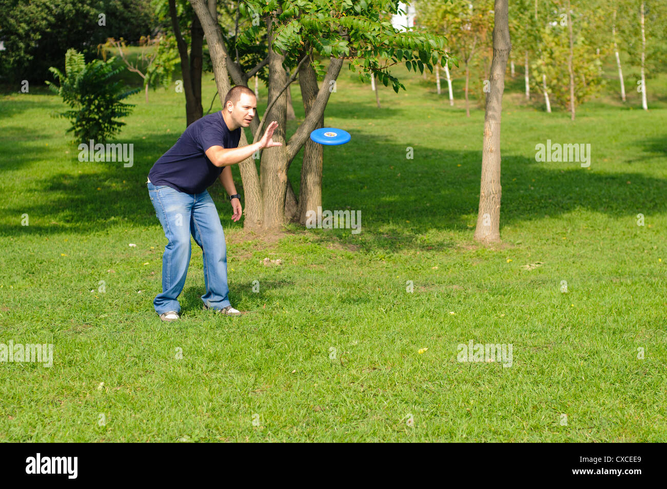 Young man playing frisbee on green grass Stock Photo - Alamy