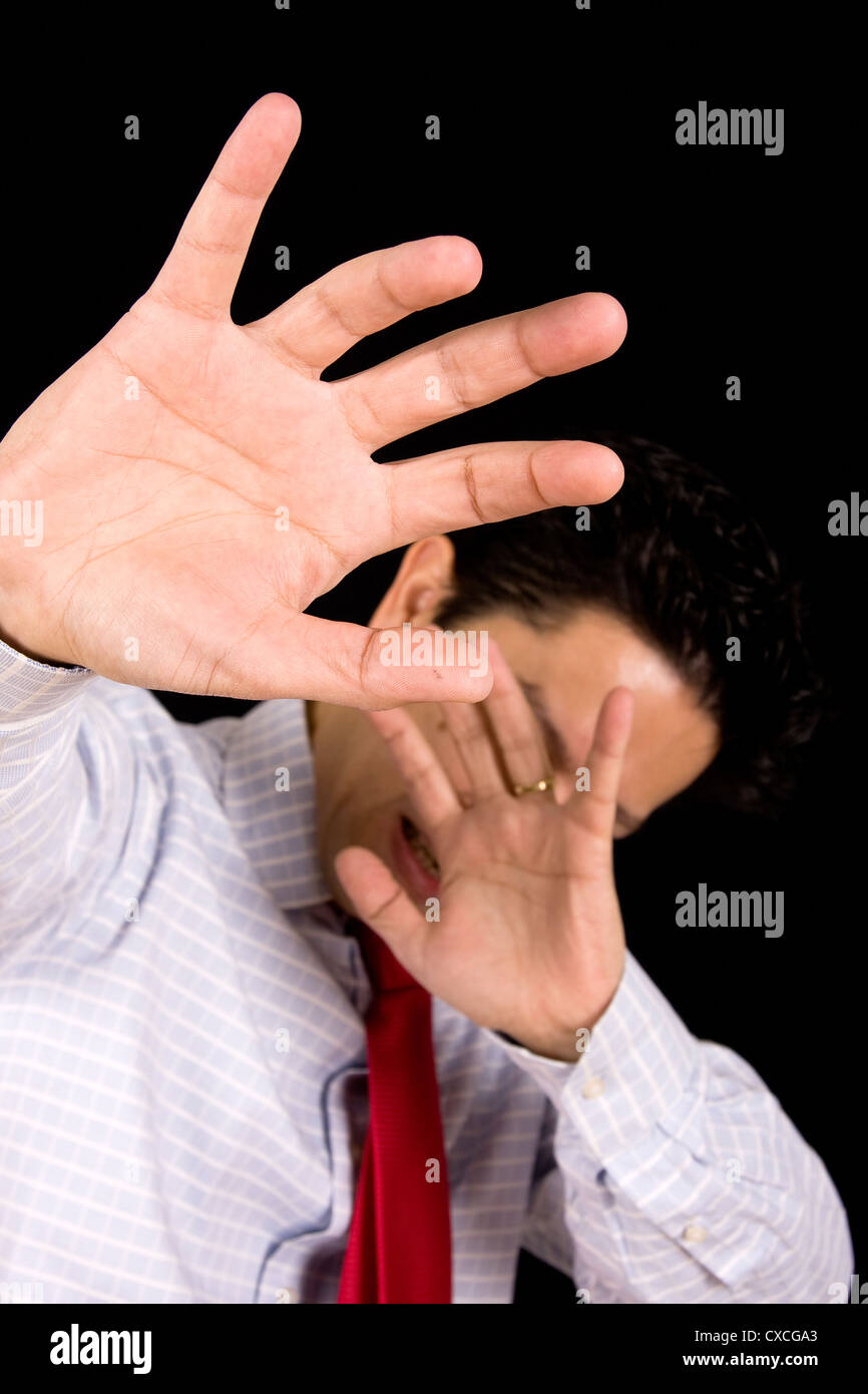 Man isolated on black hiding his head with the hands Stock Photo - Alamy