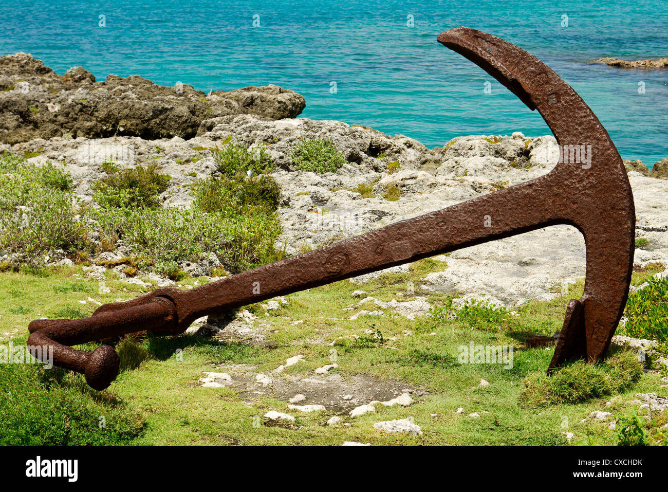 Large rusty anchor on rocky sea shore Stock Photo - Alamy