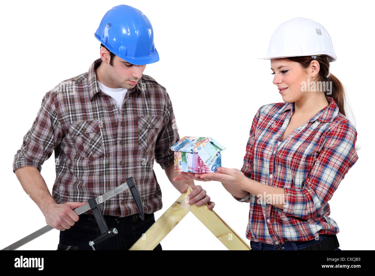 Builders with a house made out of money Stock Photo - Alamy