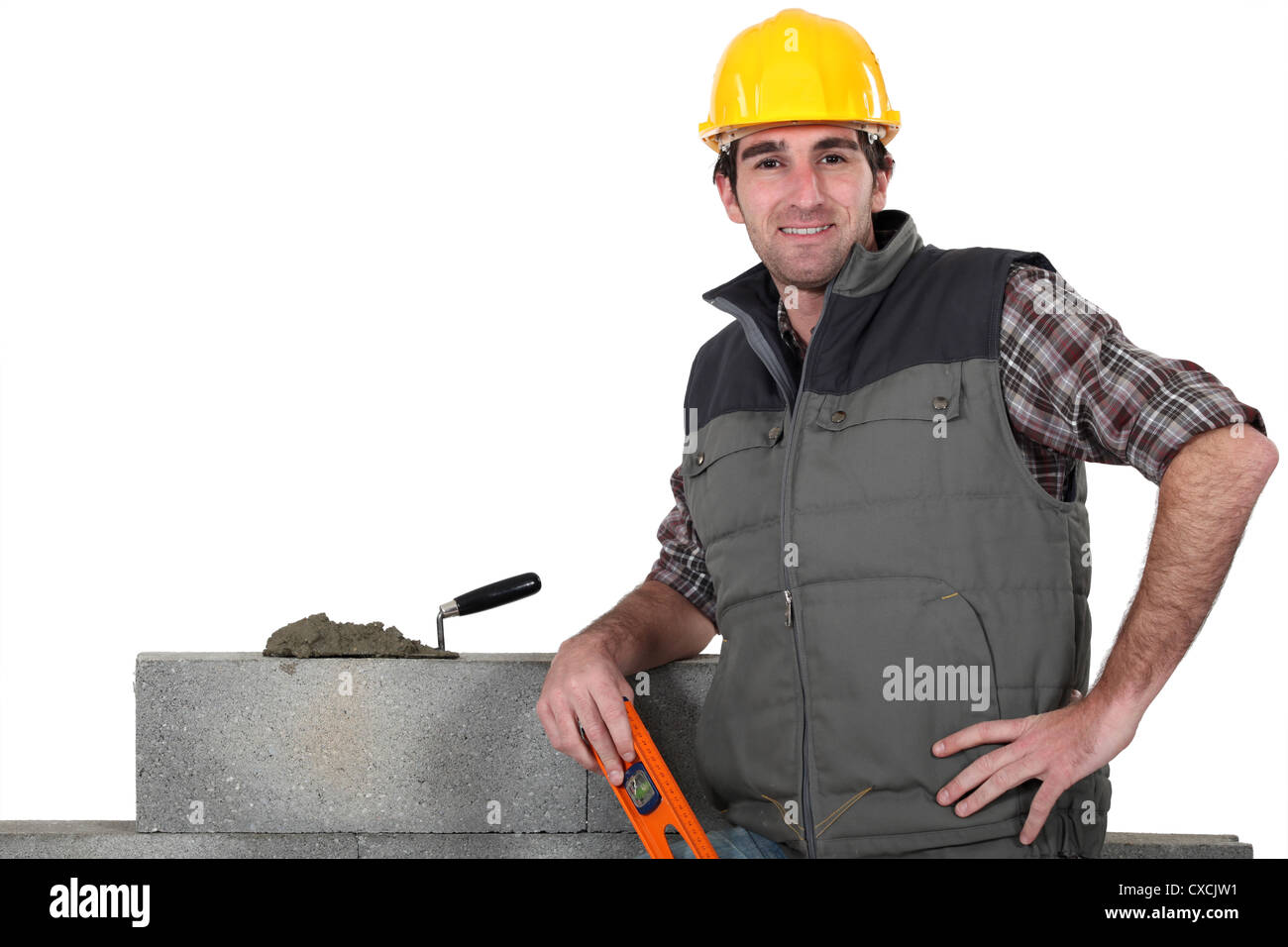 bricklayer posing near wall with arm akimbo Stock Photo - Alamy