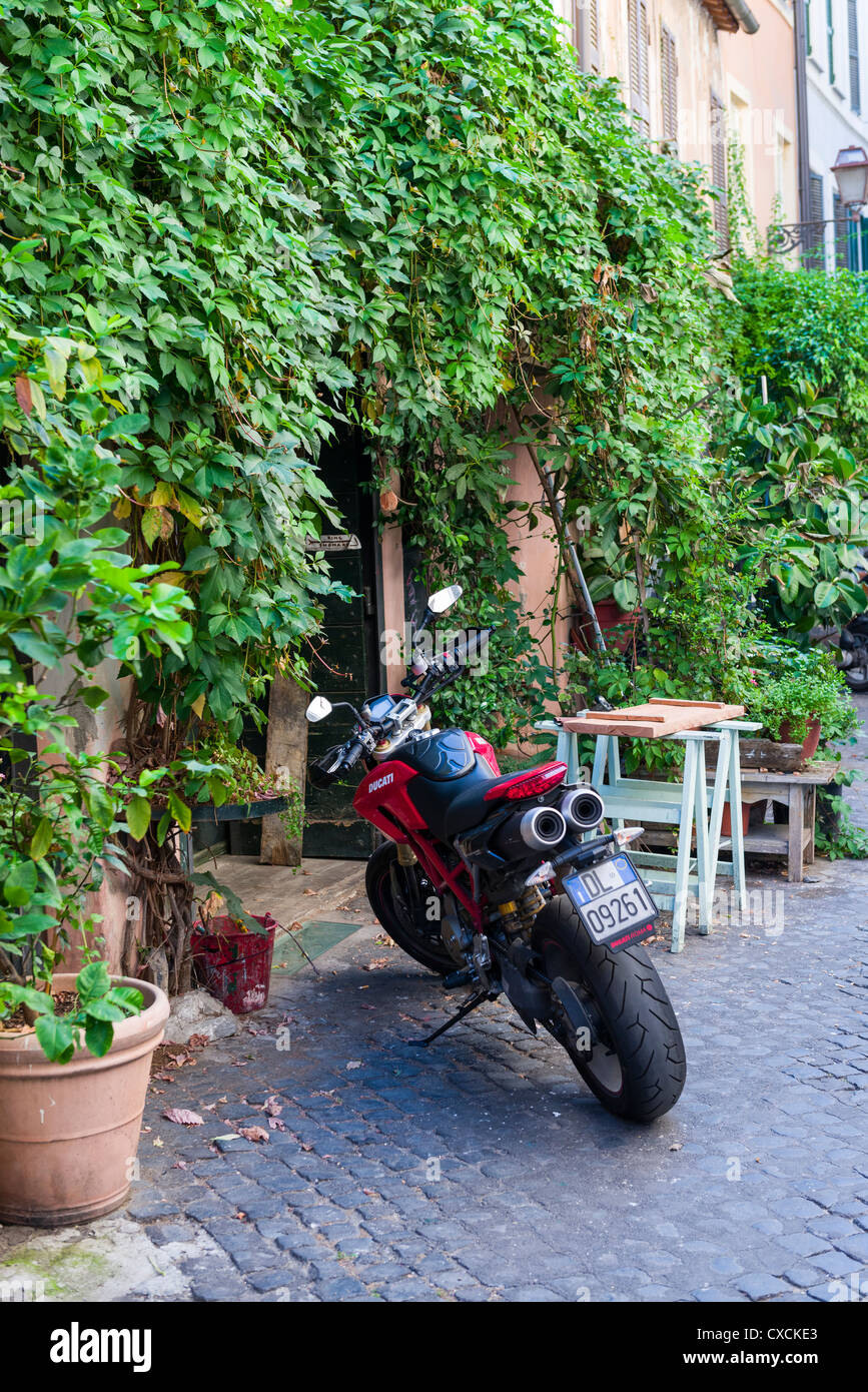 Ducati motorbike outside a ivy covered house in a back streets of Rome ...