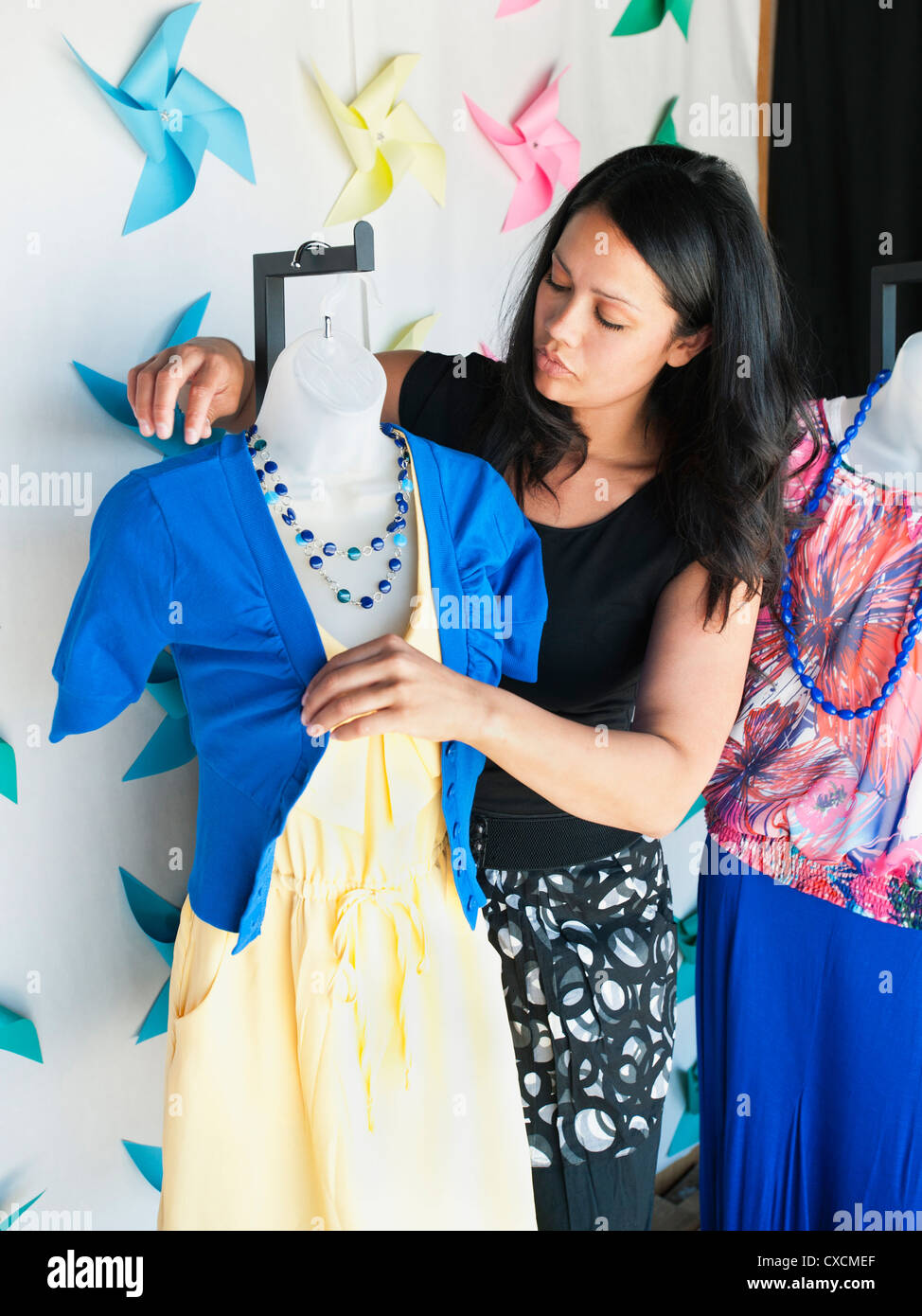 Woman dressing mannequins in store Stock Photo - Alamy