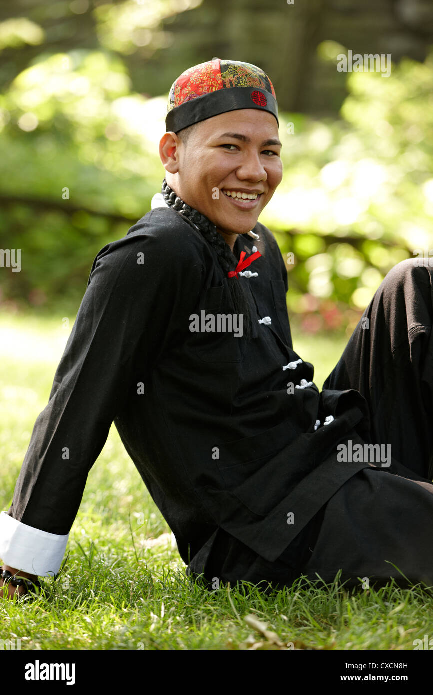 Man in traditional Asian clothing sitting in grass Stock Photo - Alamy