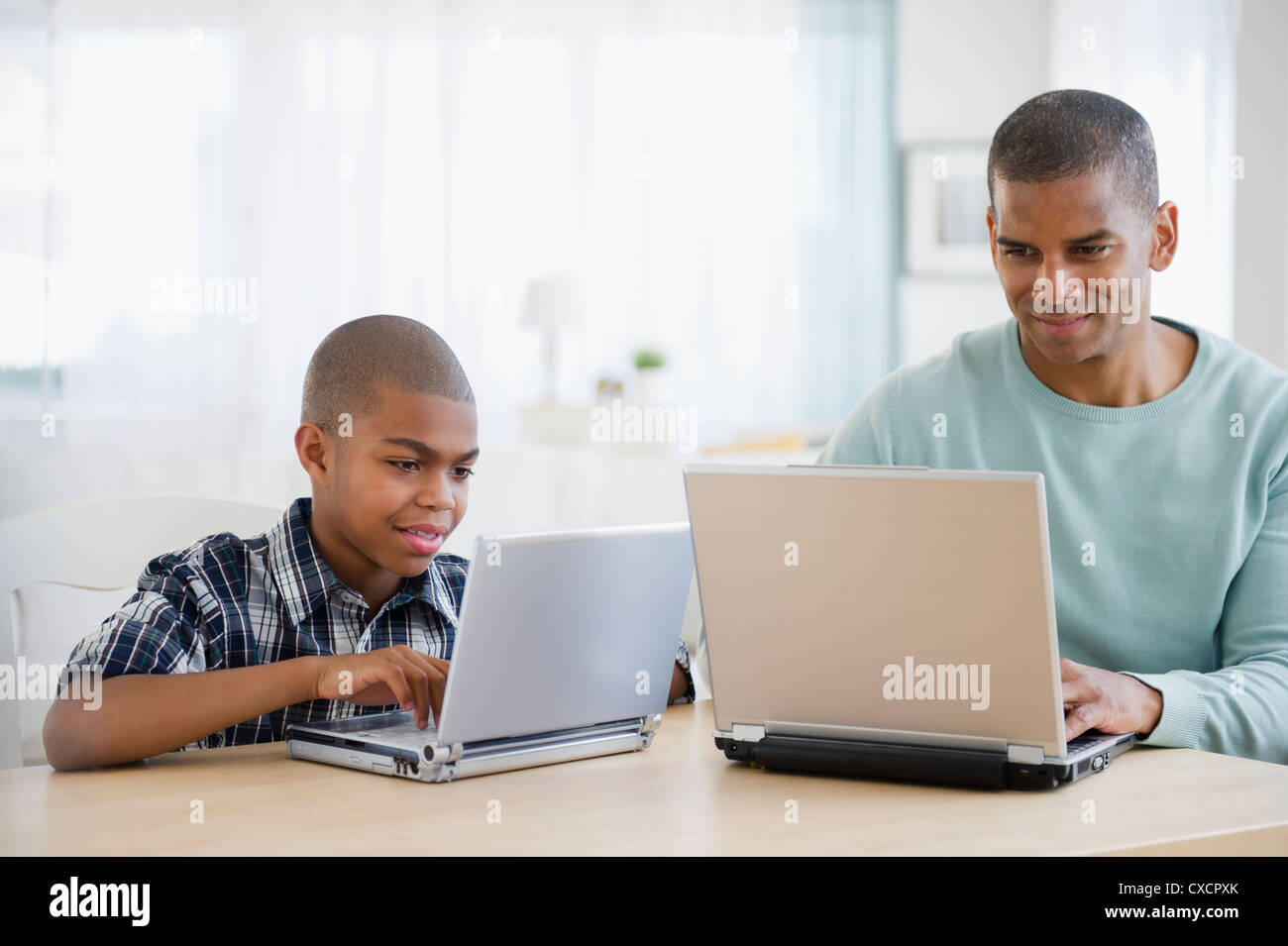 Father and son using laptops together Stock Photo - Alamy