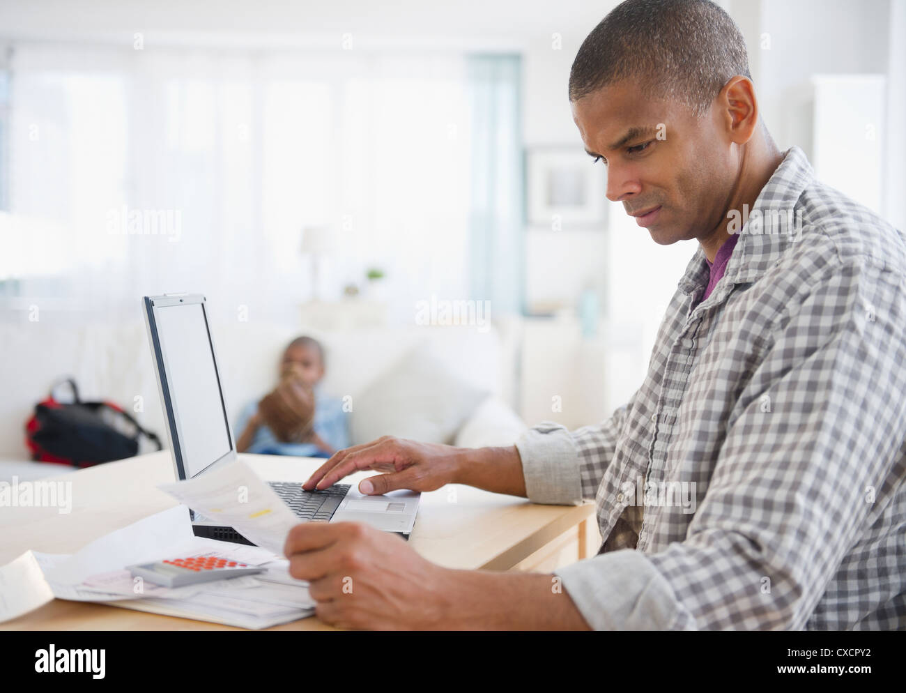 Mixed race man paying bills online Stock Photo - Alamy