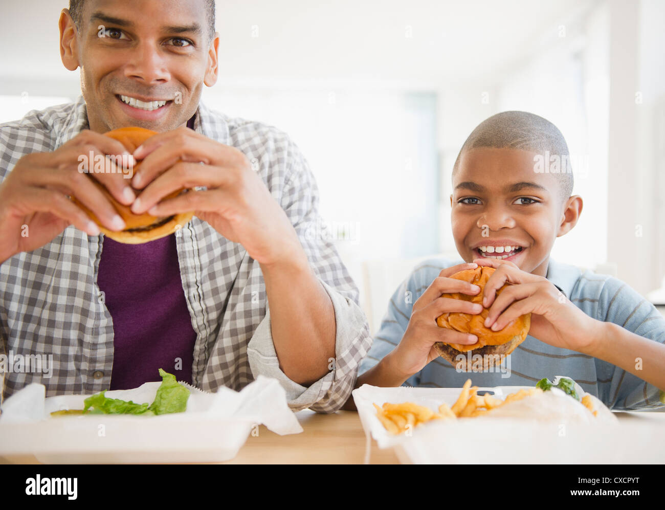 Father and son eating hamburgers Stock Photo - Alamy