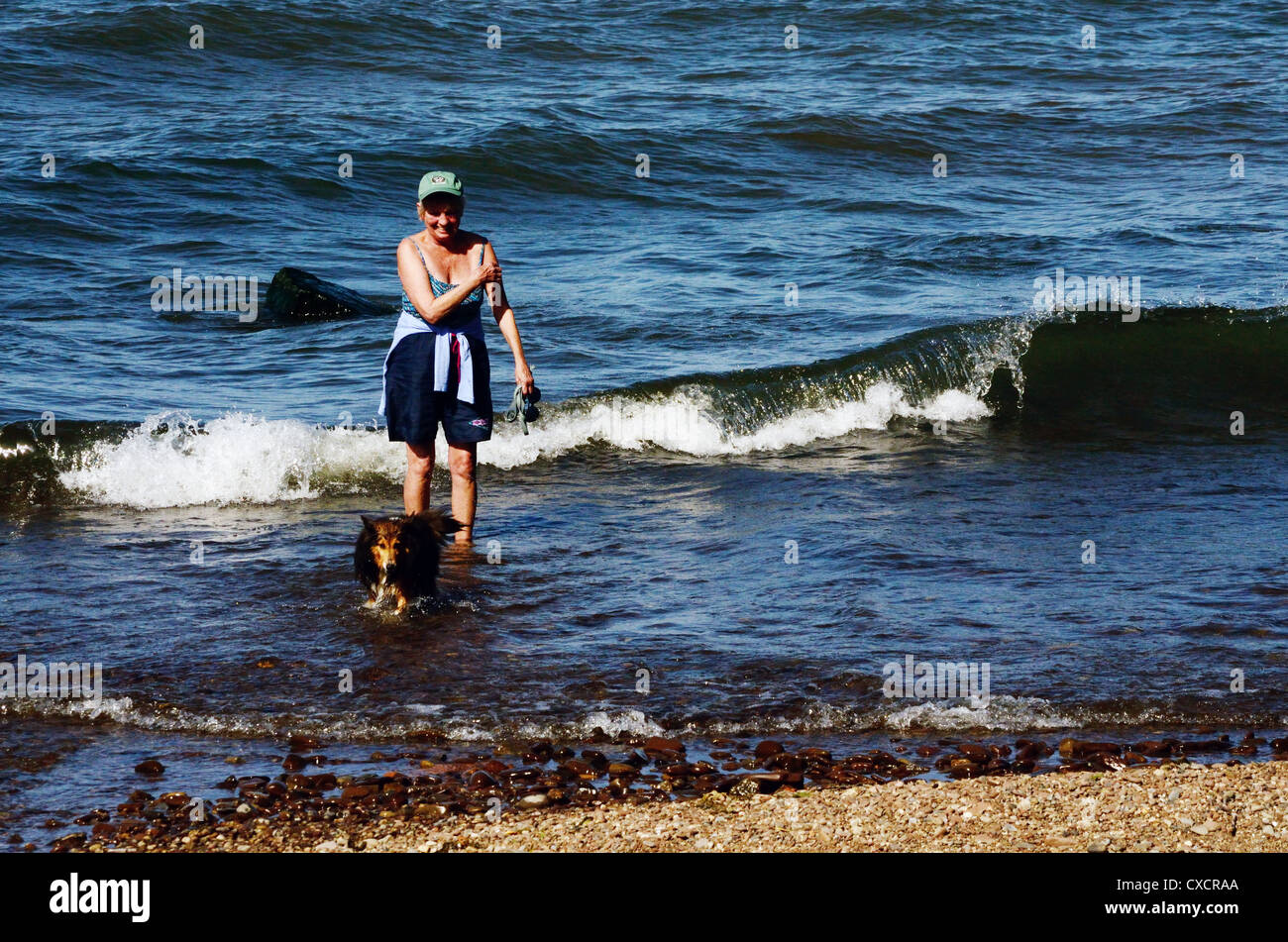 Woman and dog enjoy Lake Ontario shoreline Stock Photo - Alamy