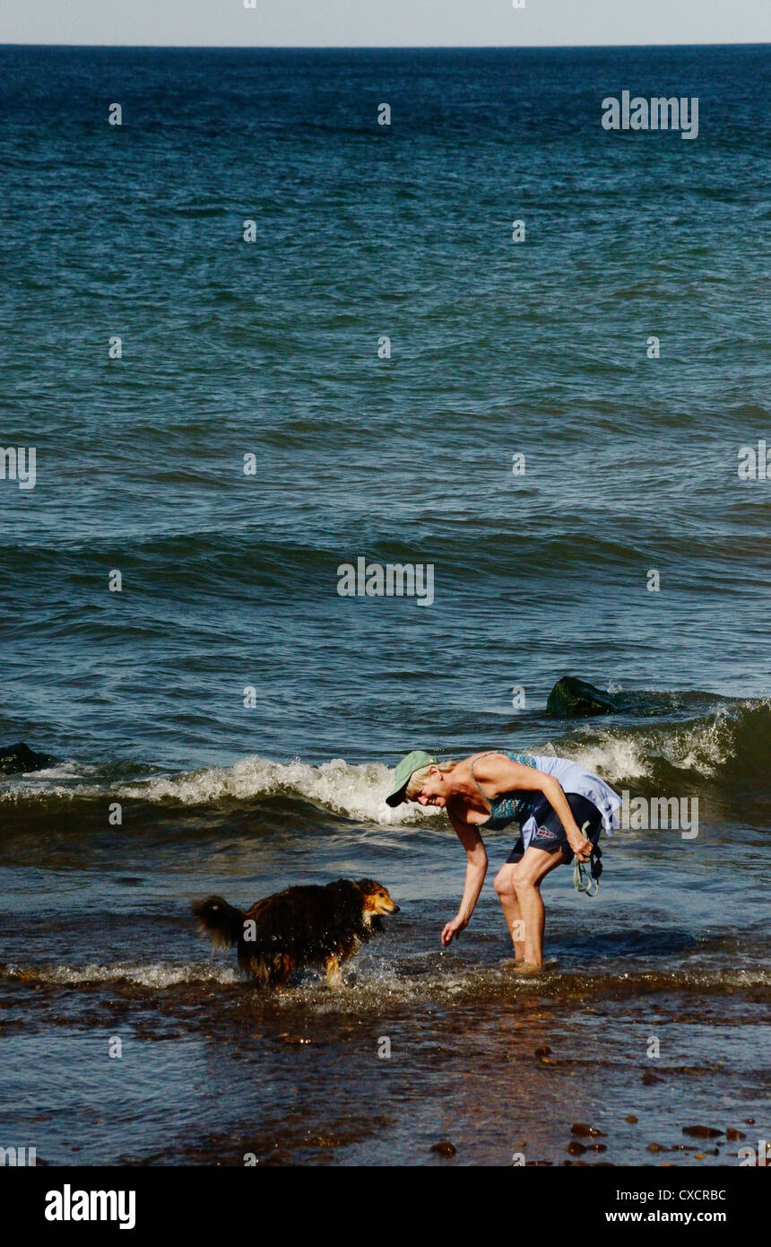 Woman and dog enjoy Lake Ontario shoreline Stock Photo - Alamy