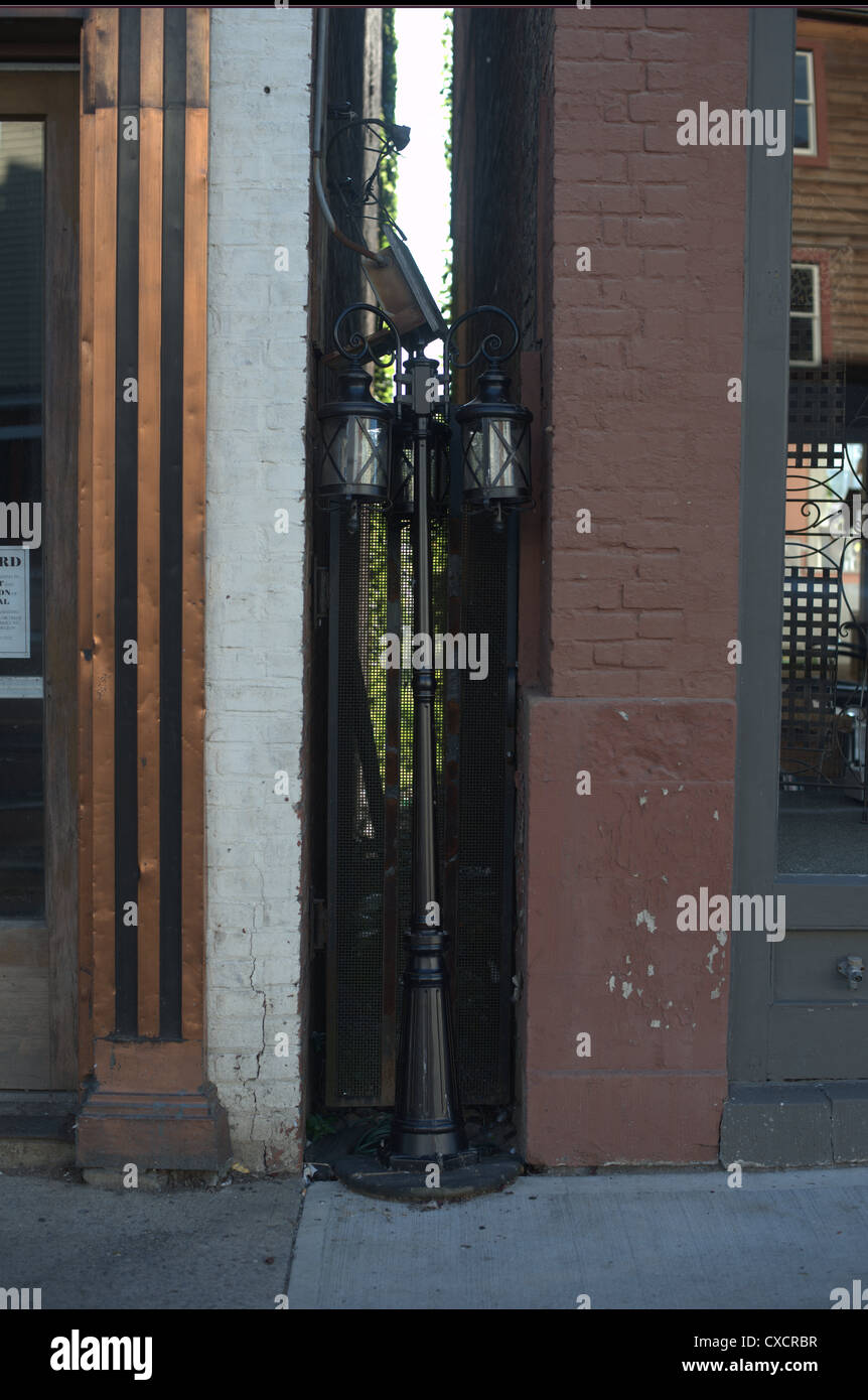disconnected street lantern propped up between two buildings in an ...