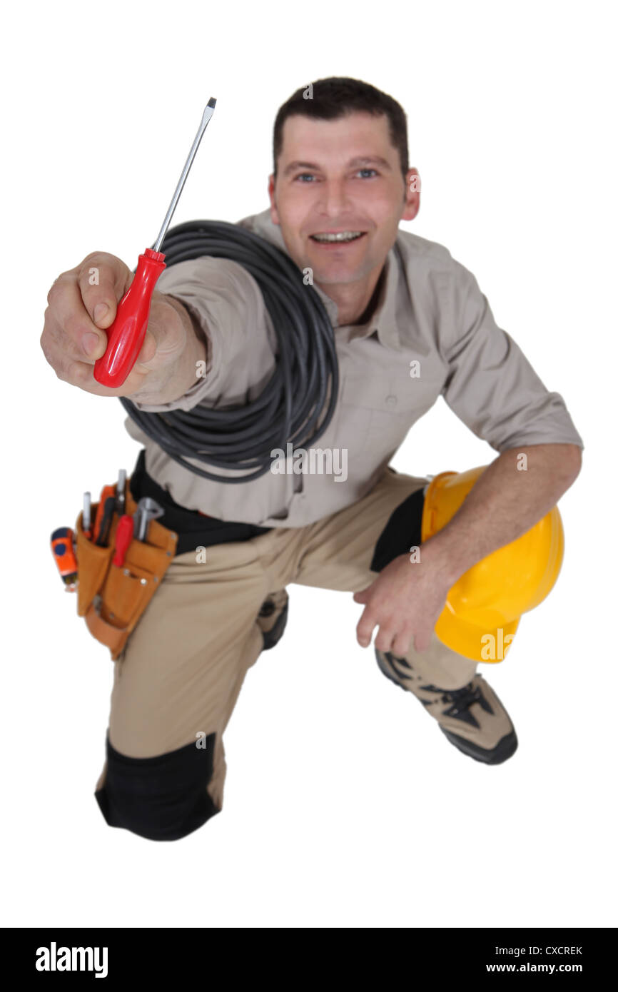 Electrician offering screwdriver Stock Photo - Alamy