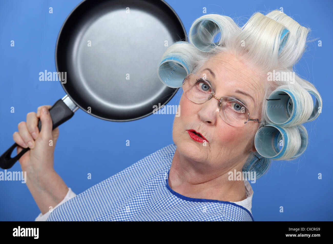 Elderly lady attacking with frying pan Stock Photo - Alamy