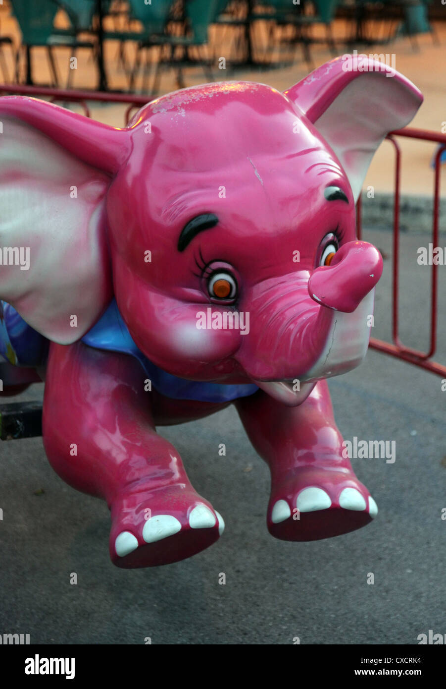 It's a photo of a pink elephant of a carousel or Merry-go-round in an ...