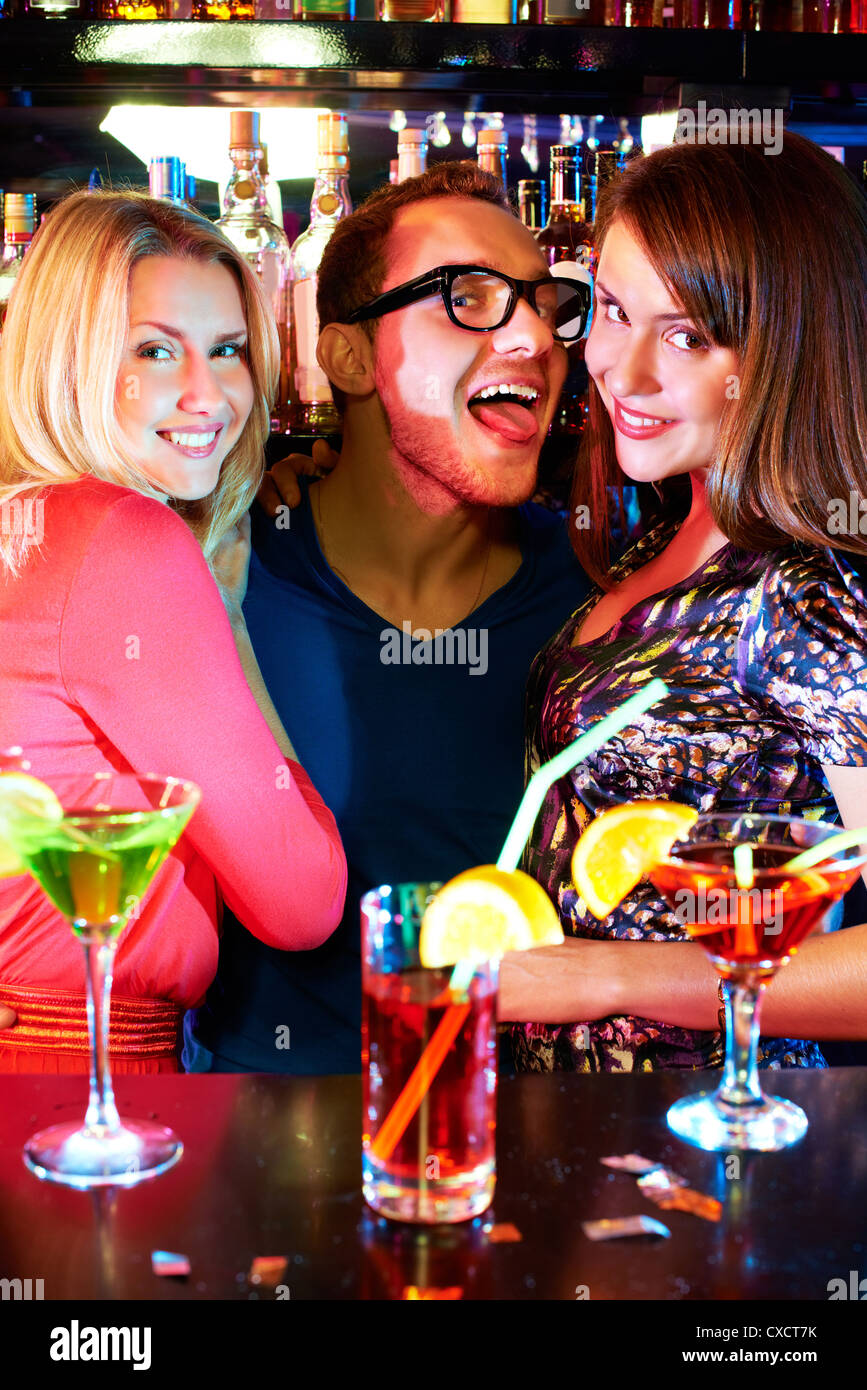 Portrait of happy girls and funny barman looking at camera at party ...
