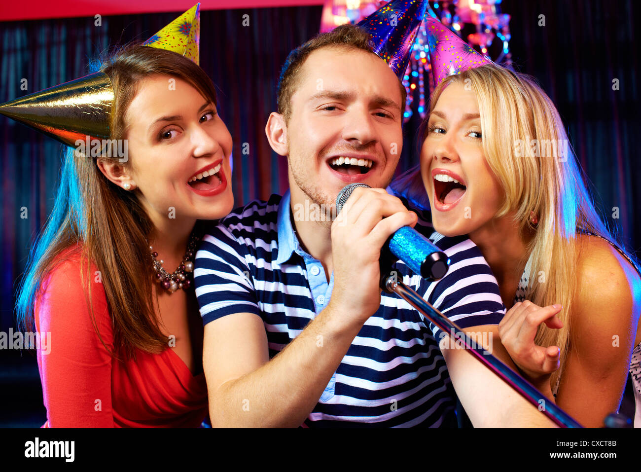Portrait of happy people singing in microphone in the karaoke bar Stock ...