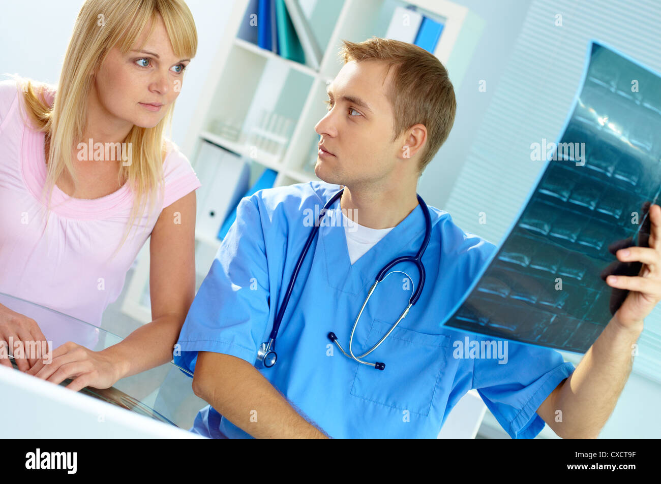 Portrait of a doctor showing x-ray to patient in hospital Stock Photo ...