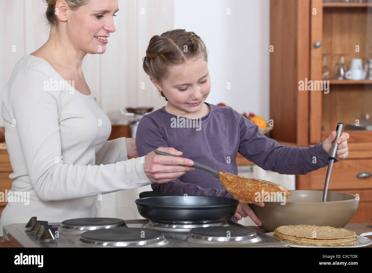 Woman teaching her daughter how to make crepes Stock Photo - Alamy