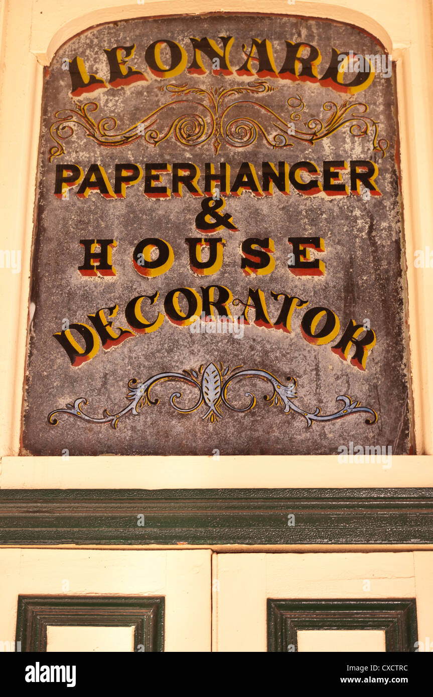 An old shop window sign for a paper hanger and house decorator Stock ...