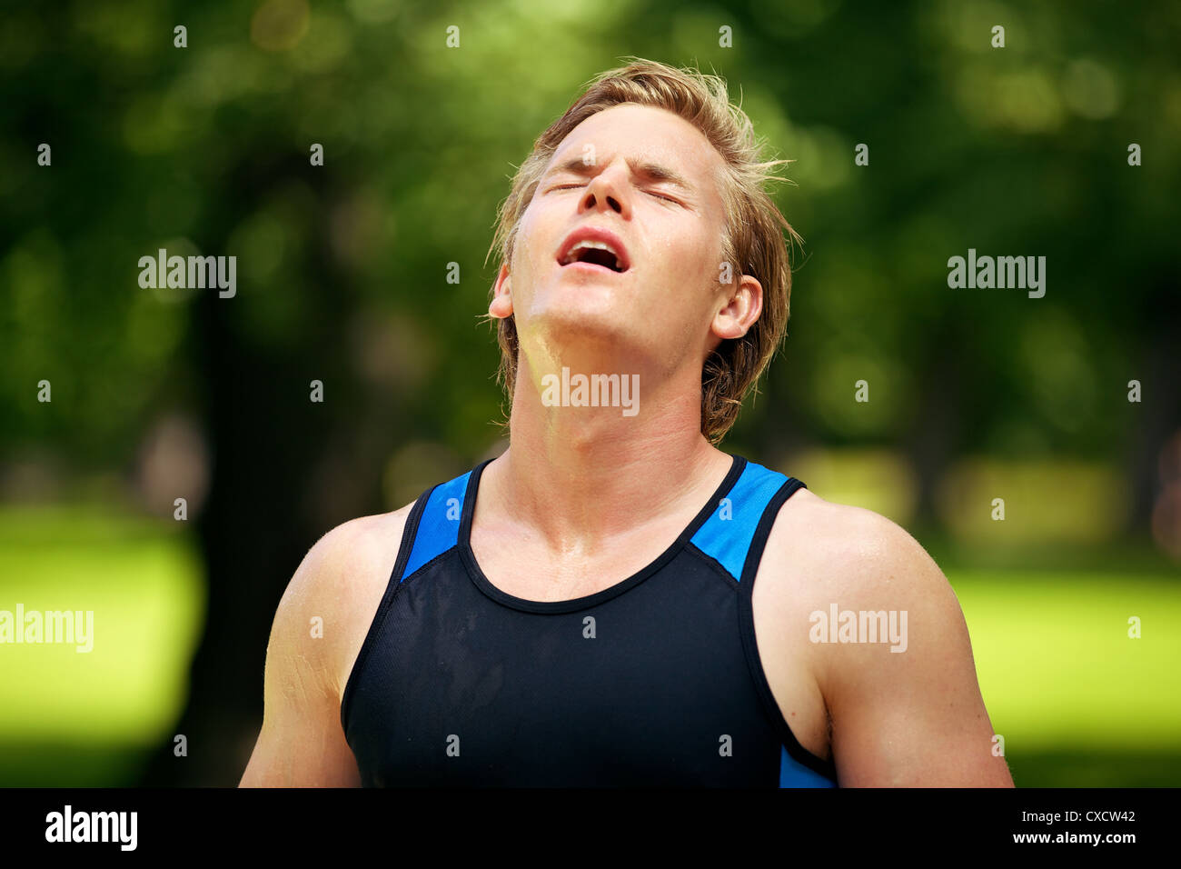 Sweaty young athlete looking up after a tiring workout Stock Photo - Alamy