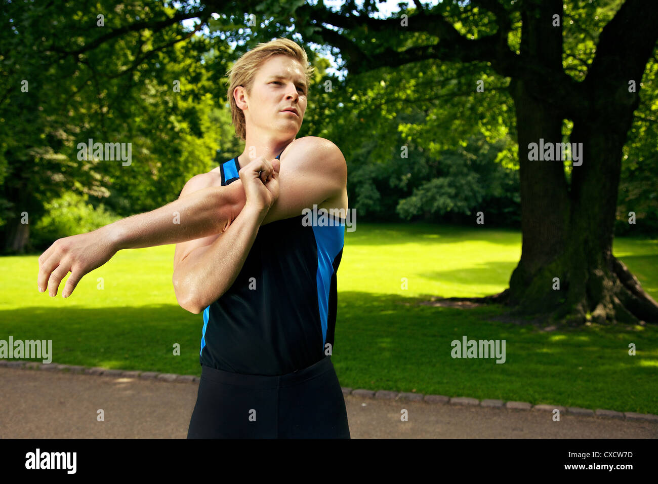 Athlete warming up by stretching his arms Stock Photo - Alamy