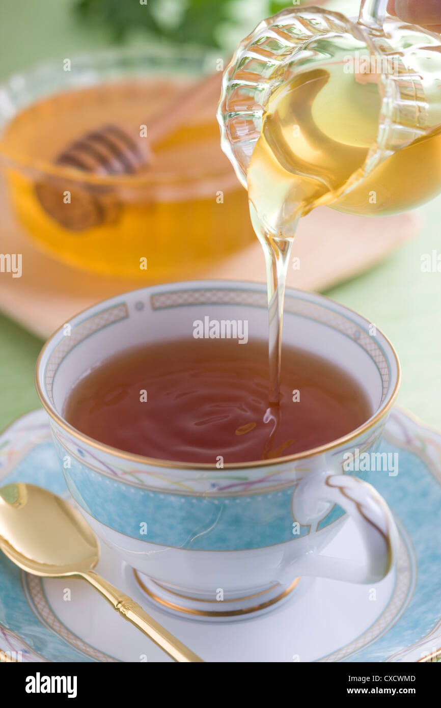Pouring Honey into Tea Stock Photo - Alamy