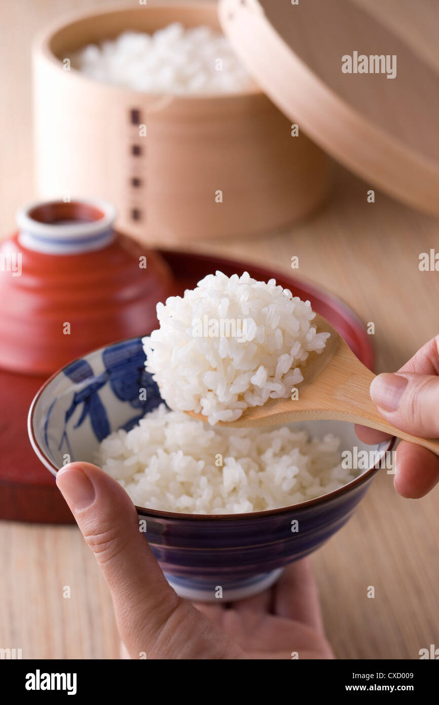 Human Hand Serving Steamed Rice in Rice Bowl Stock Photo - Alamy