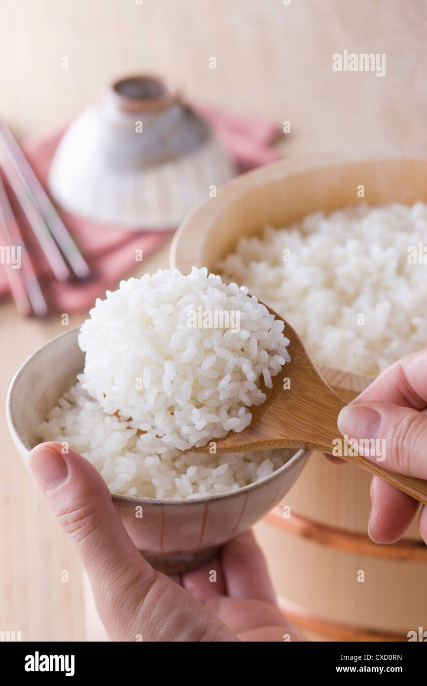 Human Hand Serving Steamed Rice into Rice Bowl Stock Photo - Alamy