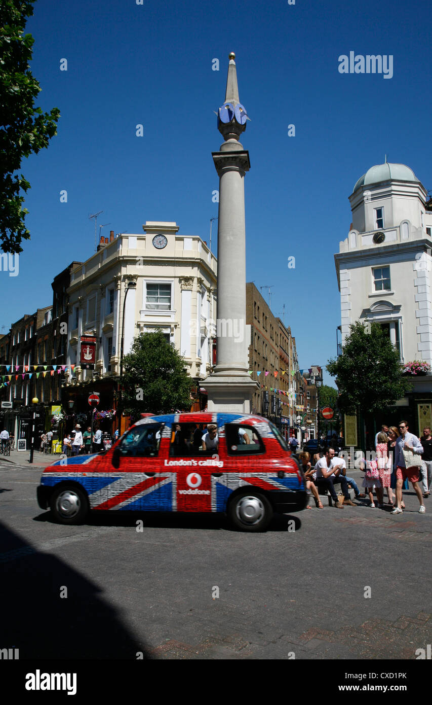 London taxi going round the Seven Dials sundial monument in the middle ...