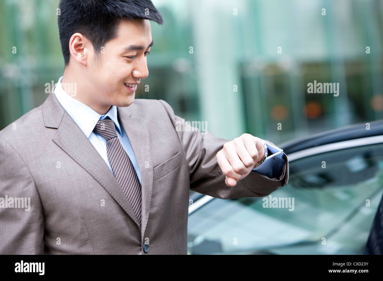 Young businessman checking time Stock Photo - Alamy
