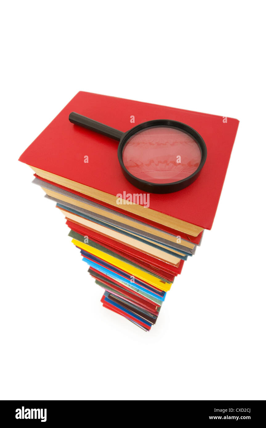 Magnifying glass over the stack of books Stock Photo - Alamy