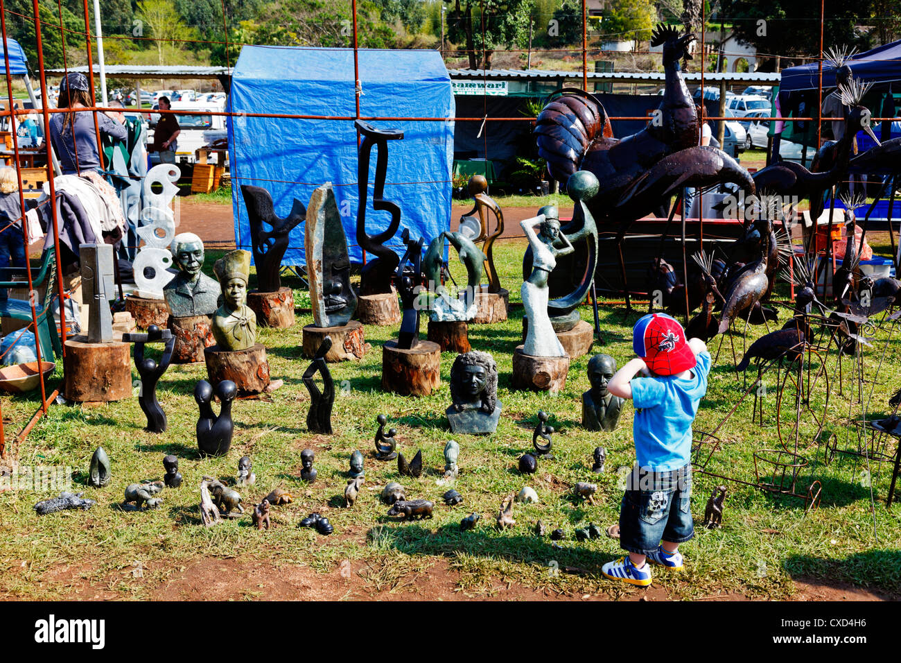 A young boy looks at a display of soapstone carvings and metal ...
