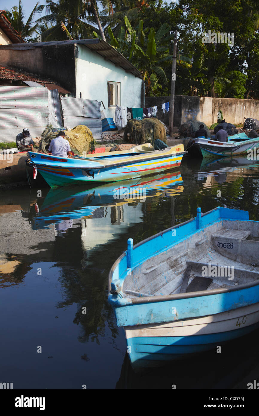 Fishermen fixing nets along Hamilton Canal, an old Dutch canal, Negombo ...