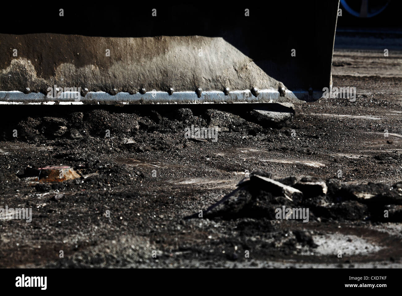 Bucket of skid loader and broken asphalt surface Stock Photo - Alamy