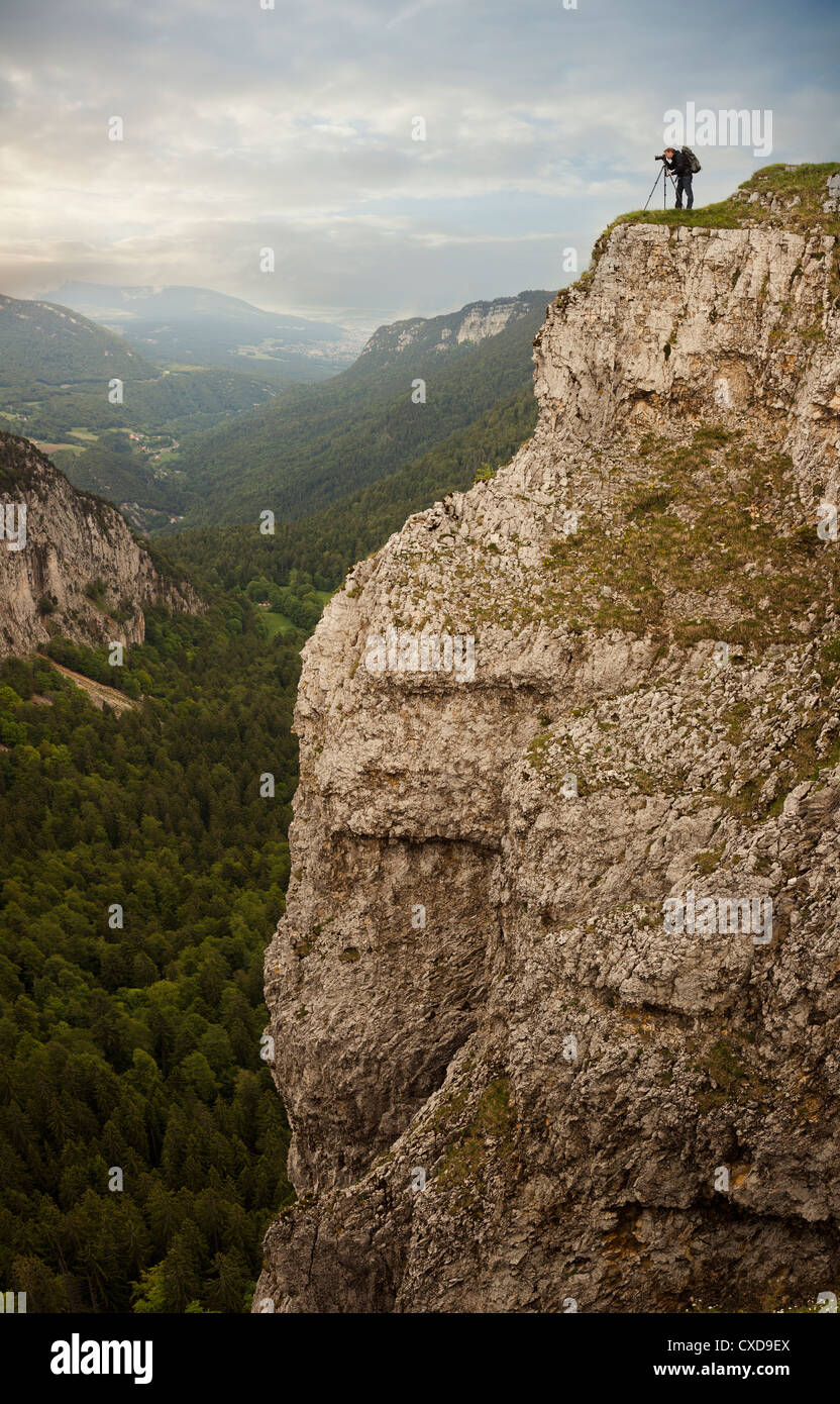 Caucasian man taking photographs from edge of cliff Stock Photo - Alamy