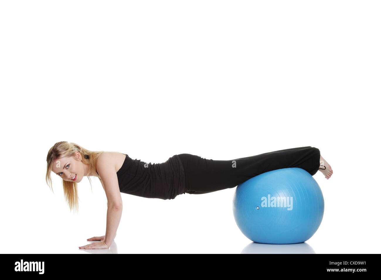 Young beautiful woman during fitness time and exercising with blue ball ...