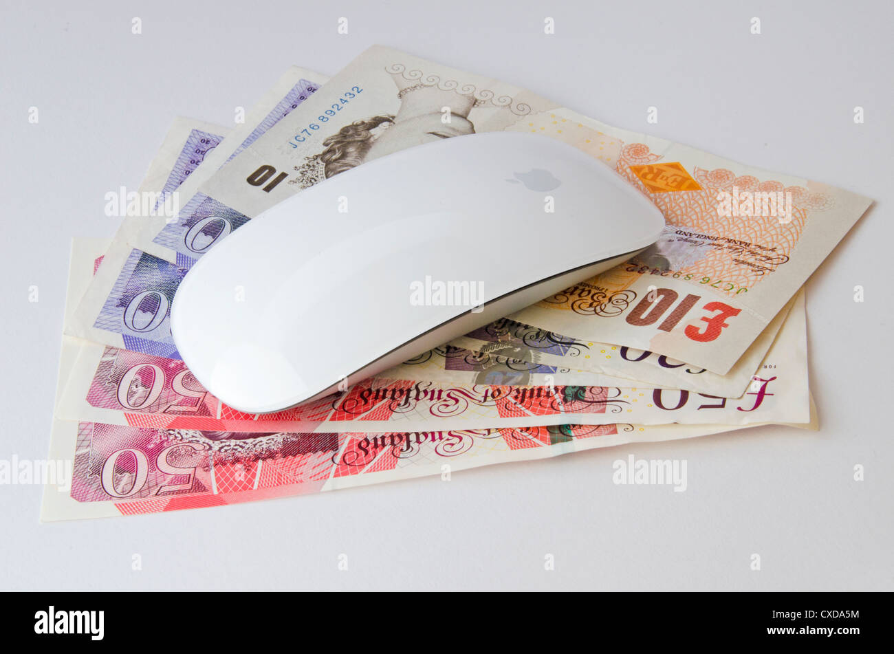Apple magic mouse sitting on pound notes Stock Photo - Alamy
