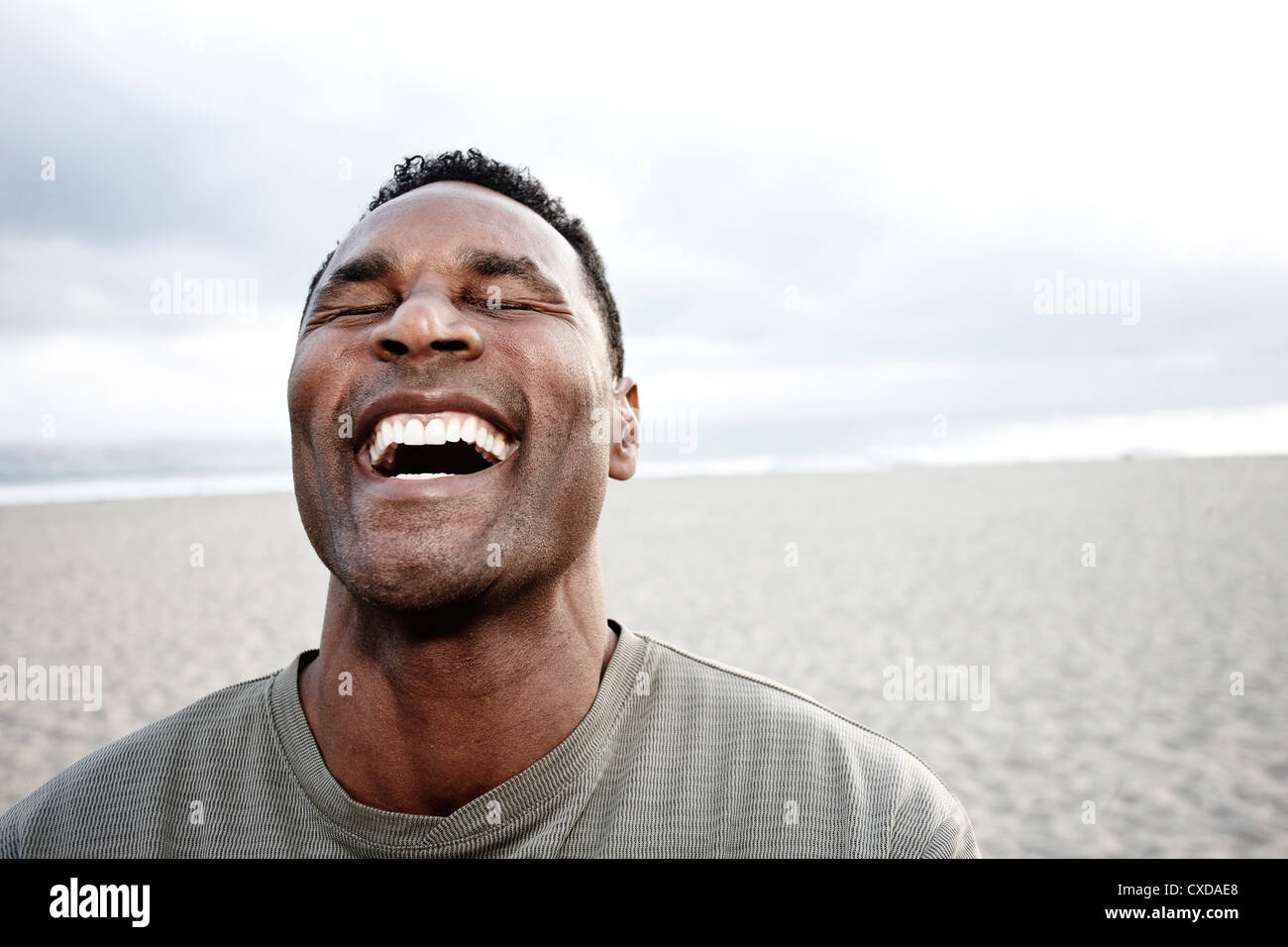 Black man laughing on beach Stock Photo - Alamy
