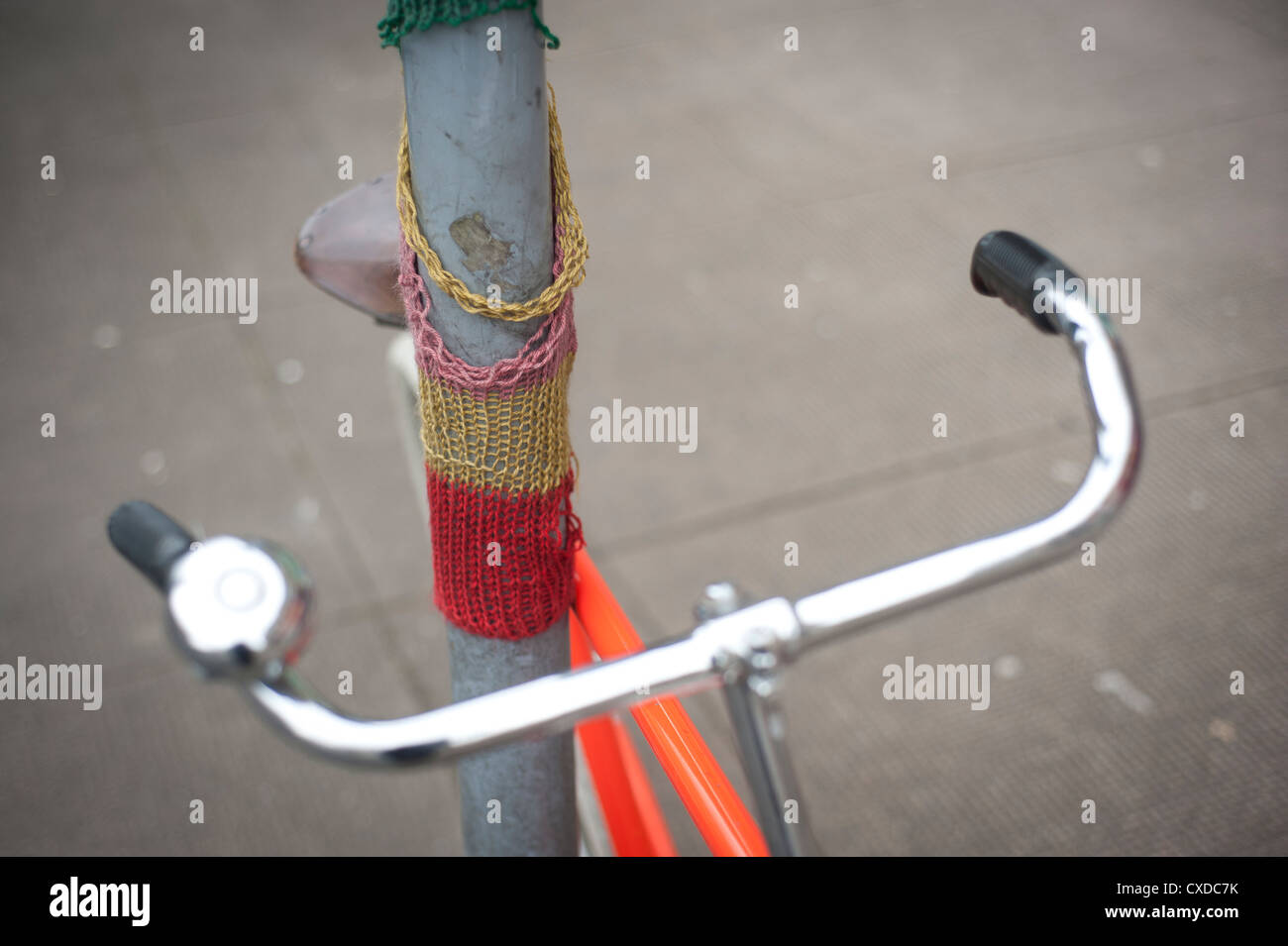 Orange single speed fixed gear racing bike with white tyres chained to ...