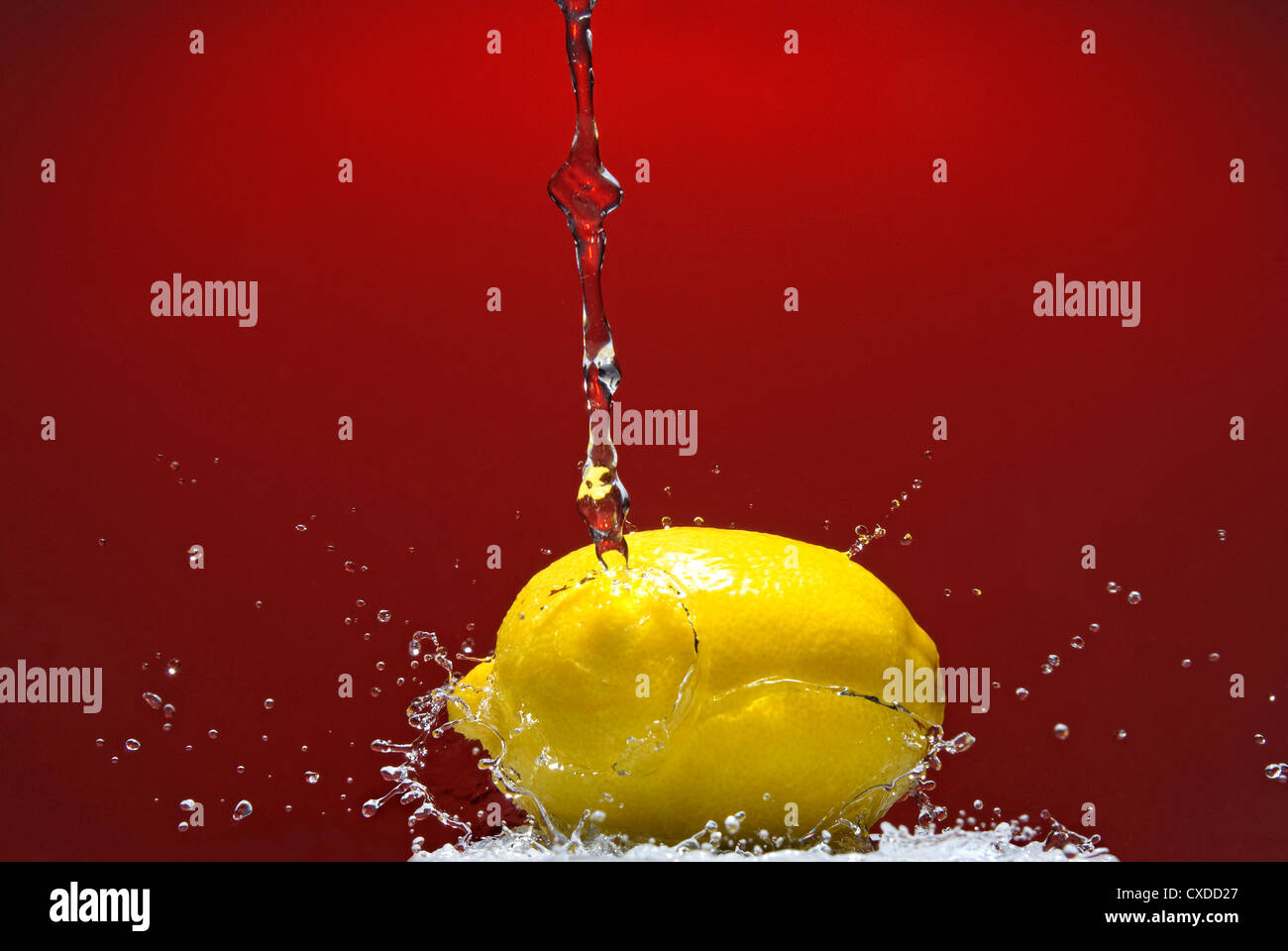 Fresh lemon and water splash on red Stock Photo - Alamy