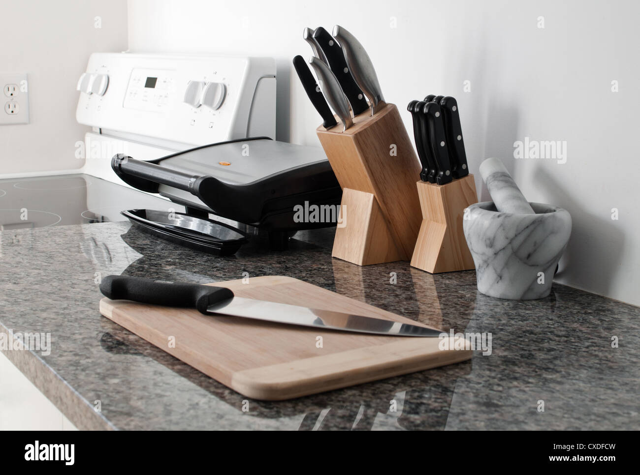 Gray granite counter with knives, mortar and pestle, panini grill and ...