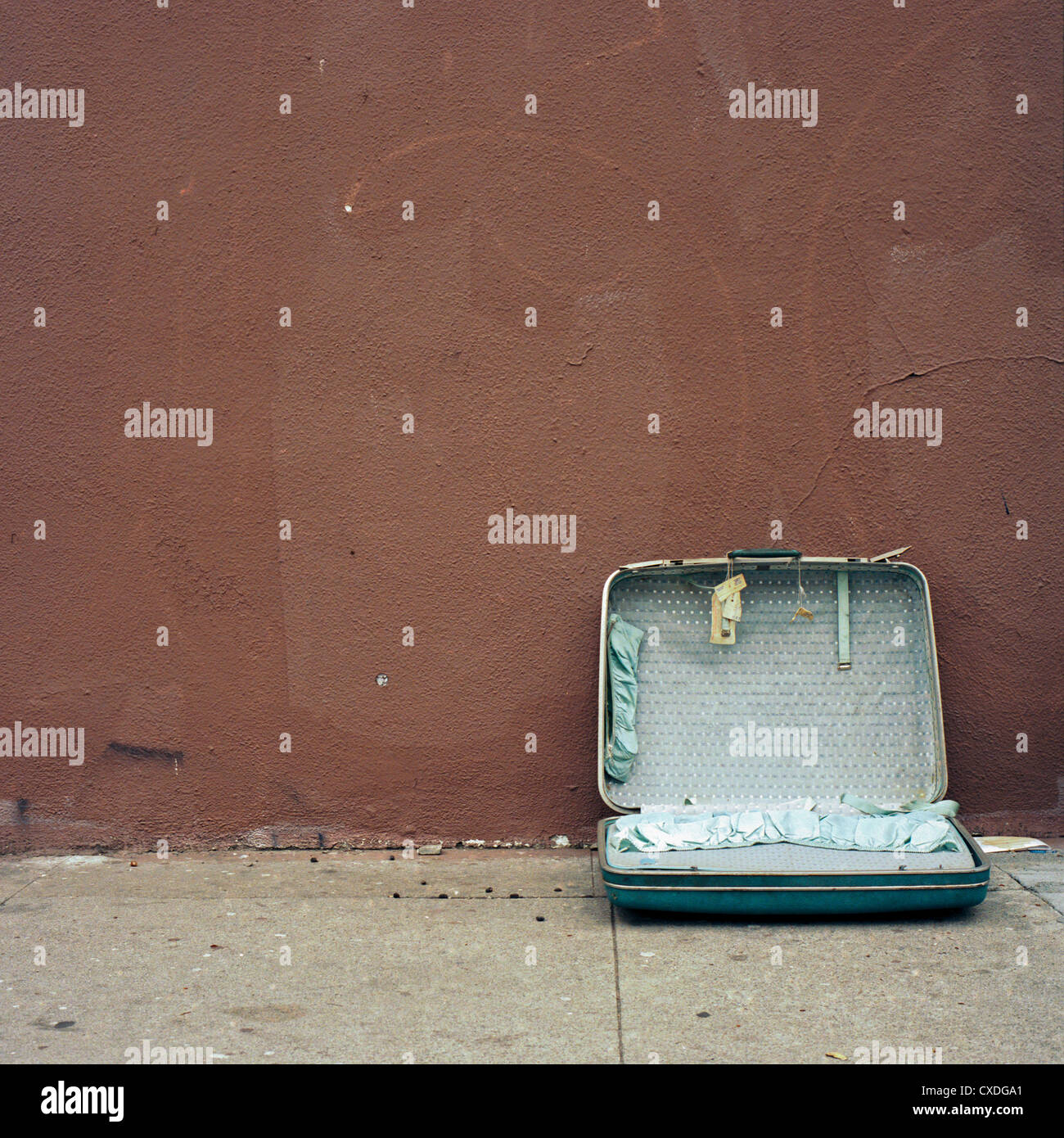 Discarded suitcase on sidewalk Stock Photo - Alamy