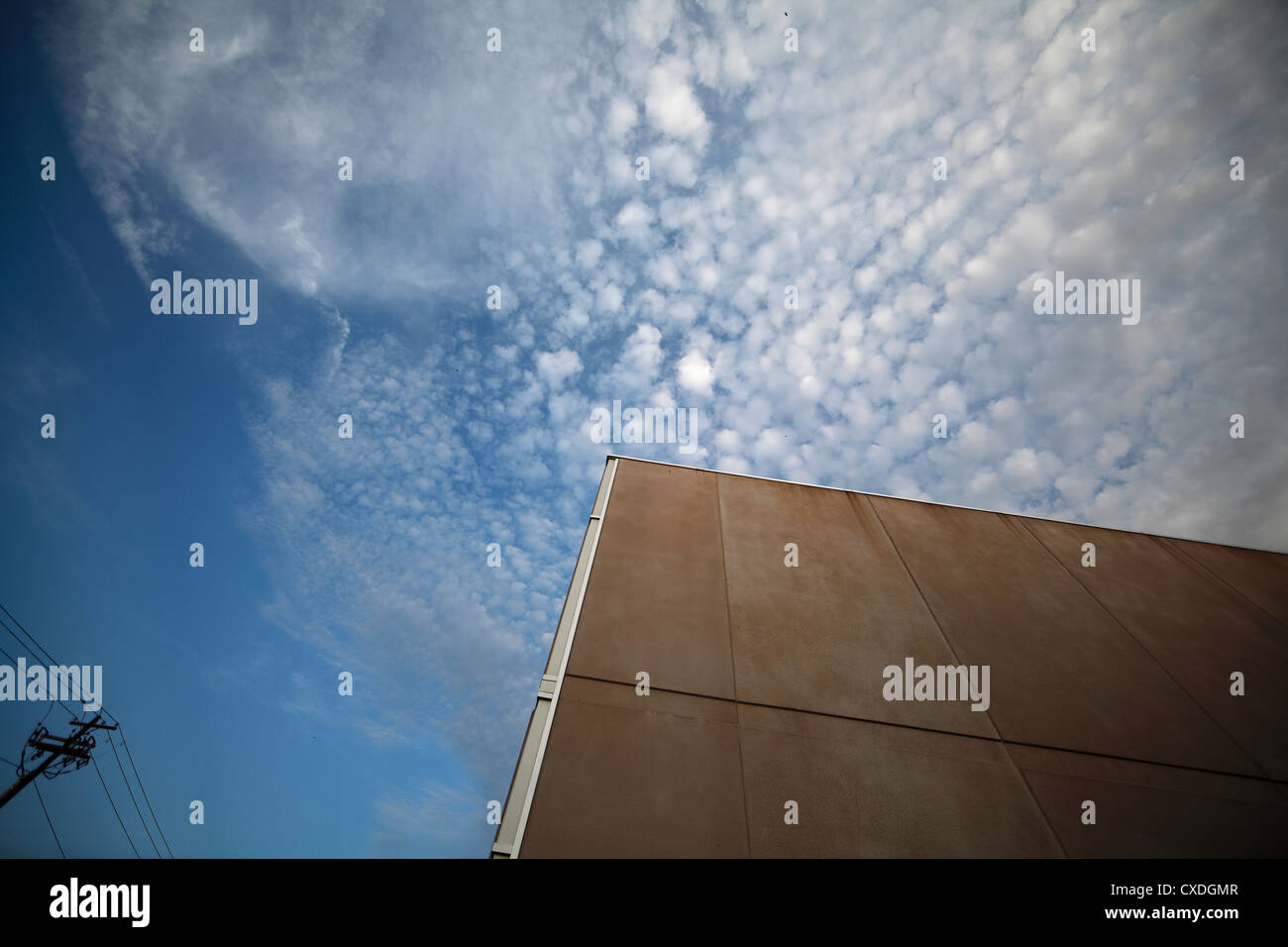 The corner of a brown building, and sky with patchy clouds Stock Photo ...
