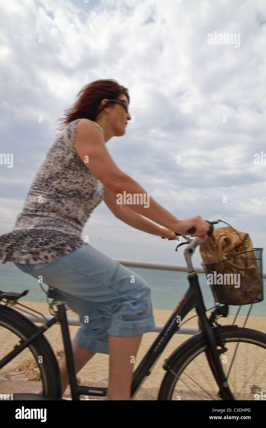 Woman Riding bike on path, person cycling on bicycle path on promenade ...