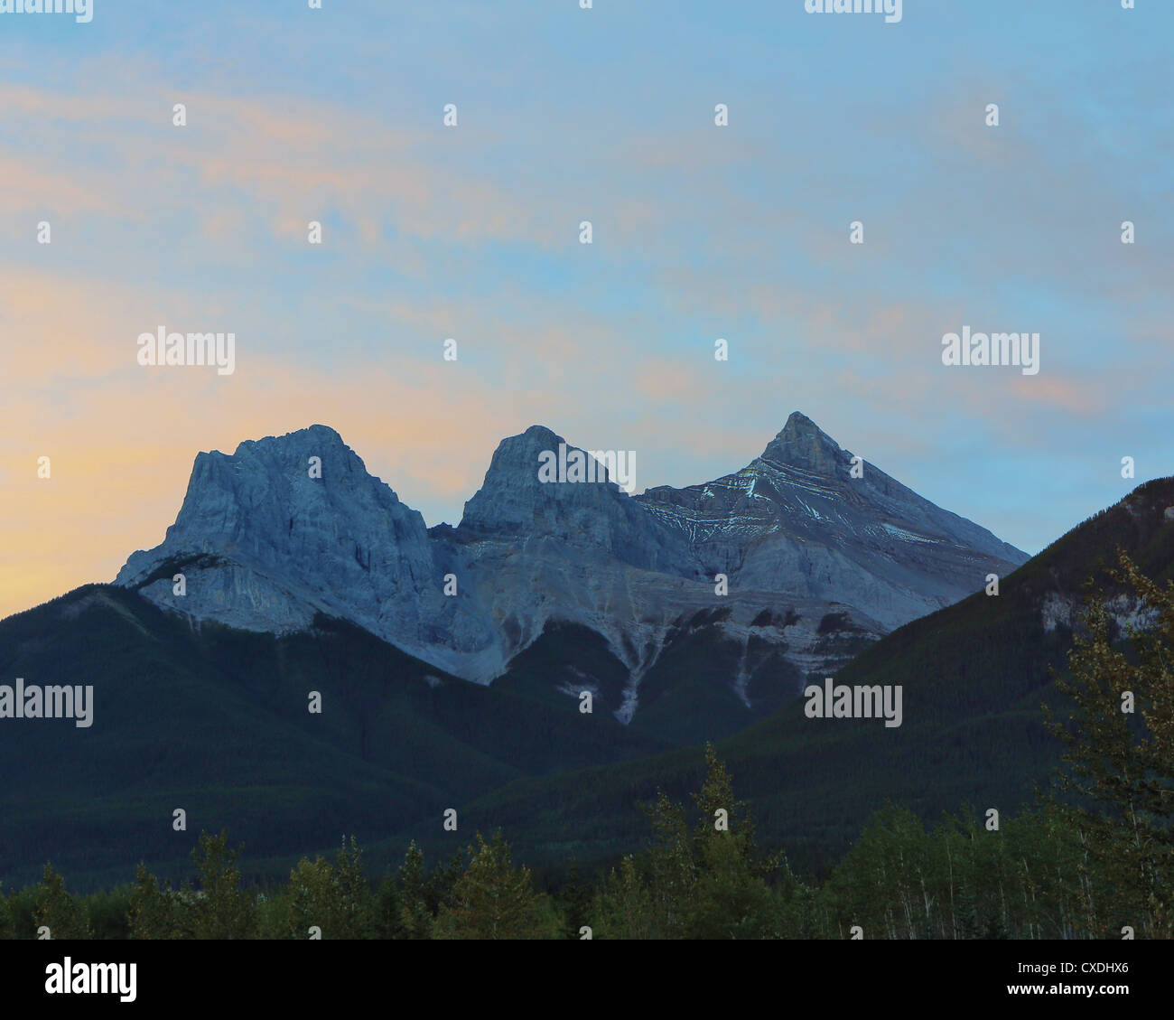 Dawn breaks over the Three Sisters mountains in Canmore Kananaskis ...