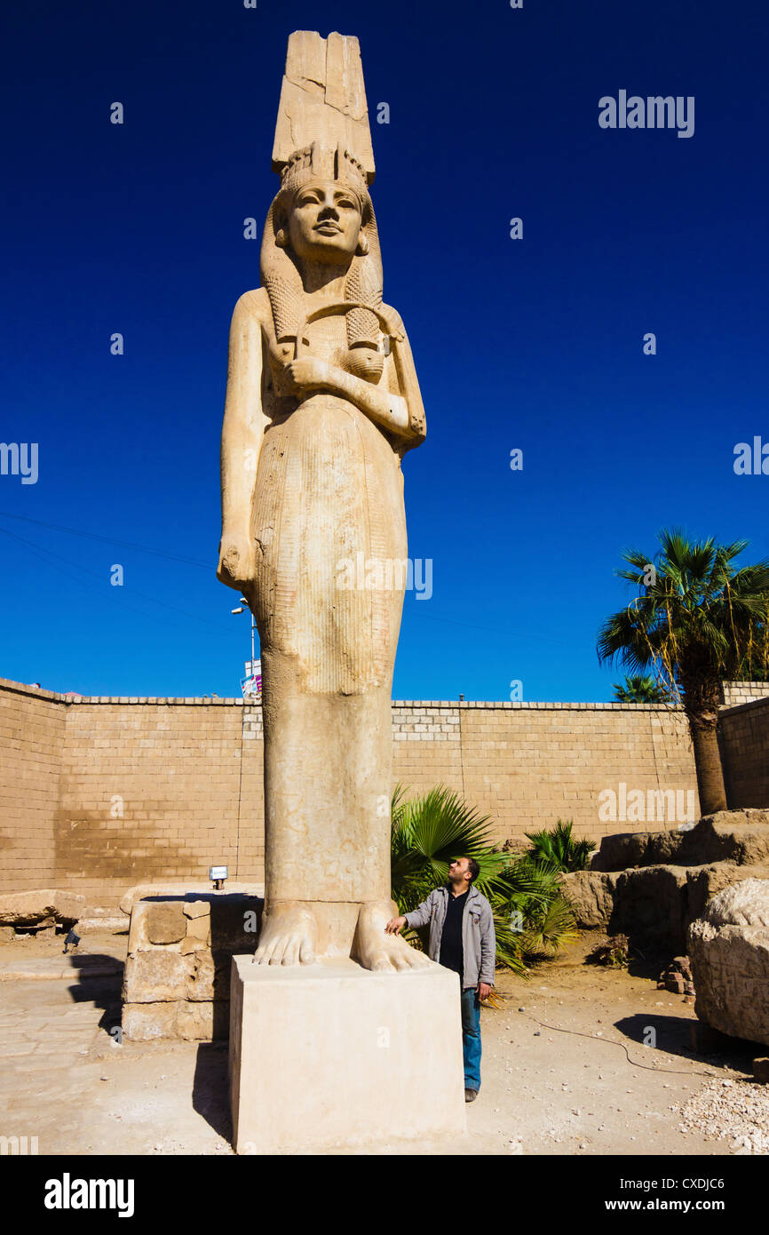 Man standing by the 11m high statue of Meret Amun, the tallest of an ...