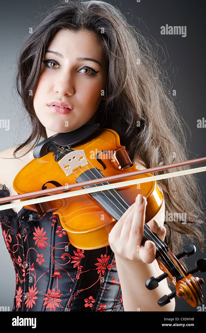 Female violin player against background Stock Photo - Alamy