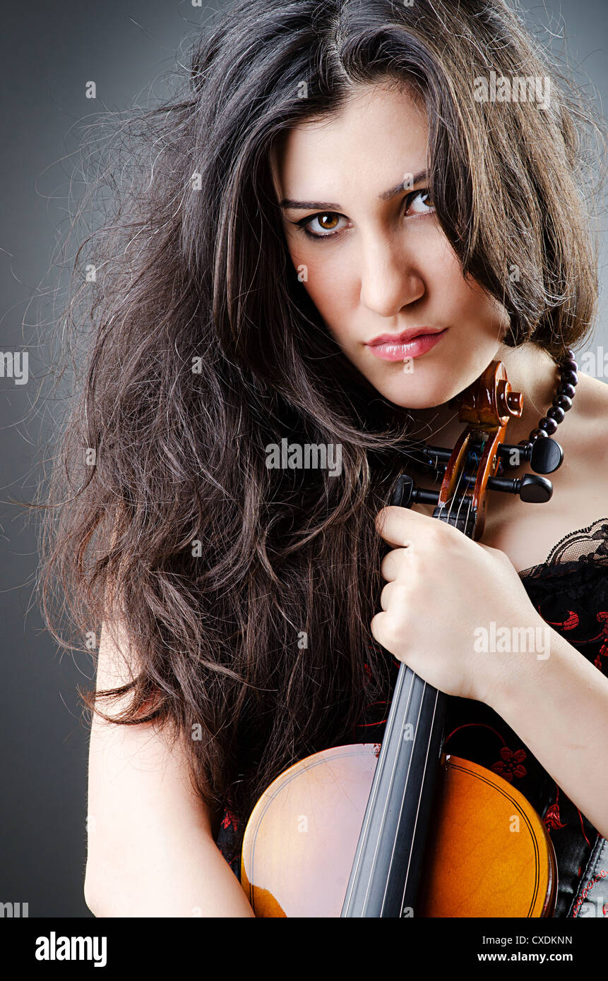 Female violin player against background Stock Photo - Alamy