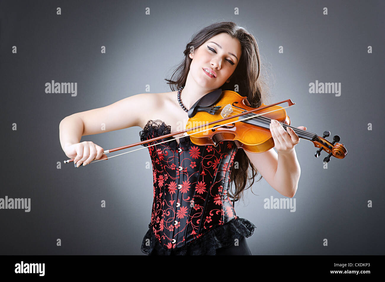 Female violin player against background Stock Photo - Alamy