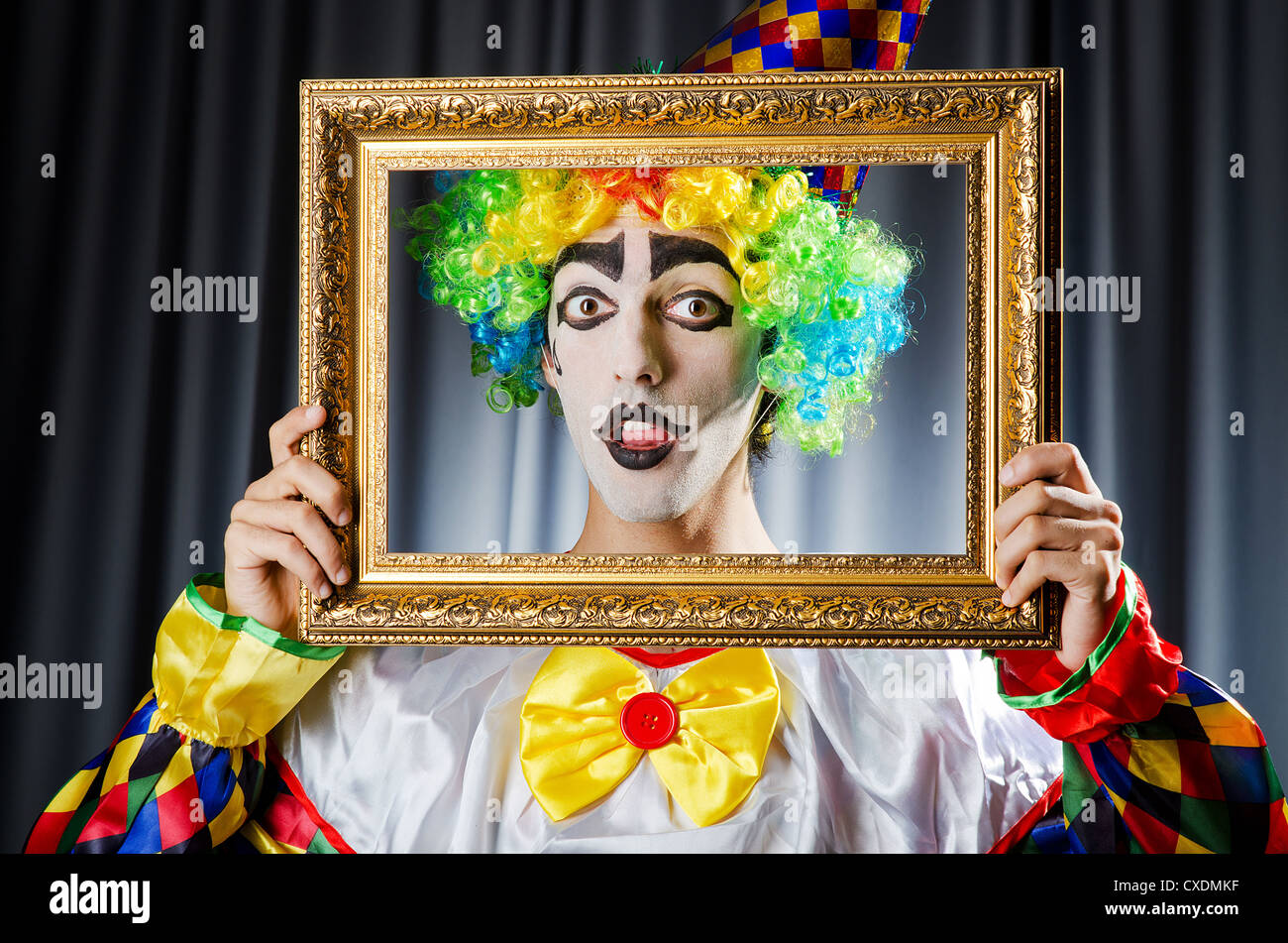 Clown with picture frames in studio Stock Photo - Alamy
